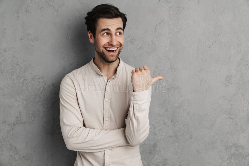 Joyful Handsome Guy Smiling and Pointing Finger Aside Stock Image ...