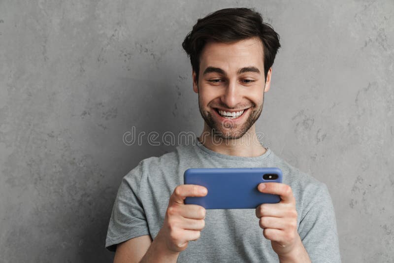 Joyful Handsome Guy Smiling and Using Mobile Phone Stock Image - Image ...