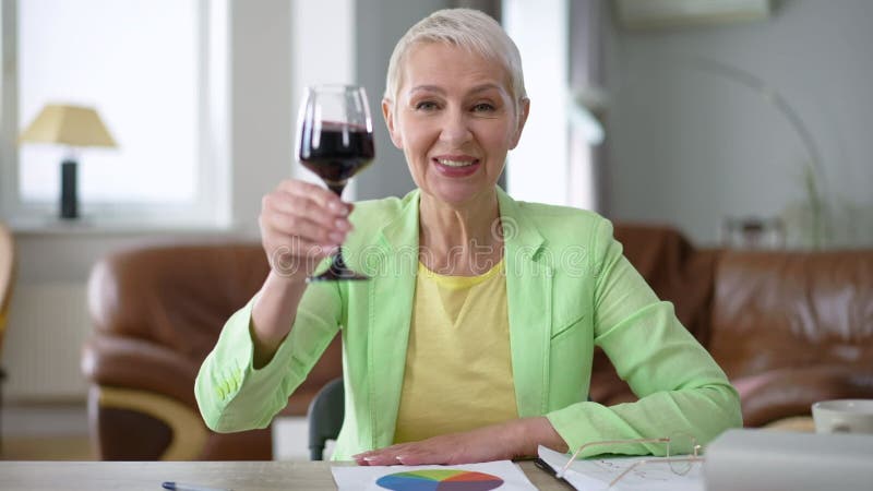Joyful Middle Aged Elegant Woman Toasting Looking At Camera Drinking