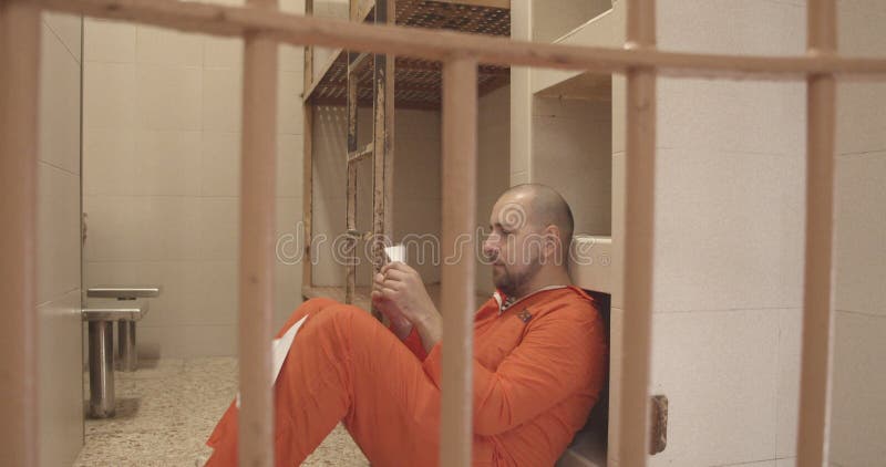 Prisoner in Orange Uniform Leans on Metal Bars Stock Footage - Video of ... Prisoner in Orange Uniform Leans on Metal Bars Stock Footage - Video of ...