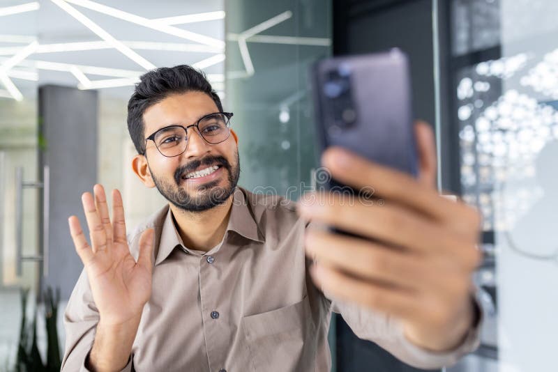 Professional Man Video Calling with a Smile in Modern Office Stock ...