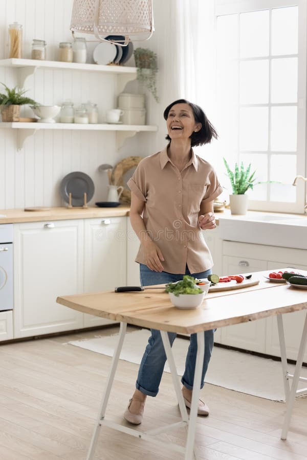 Joyful Senior Woman Dancing while Cooking in the Kitchen Stock Photo ...