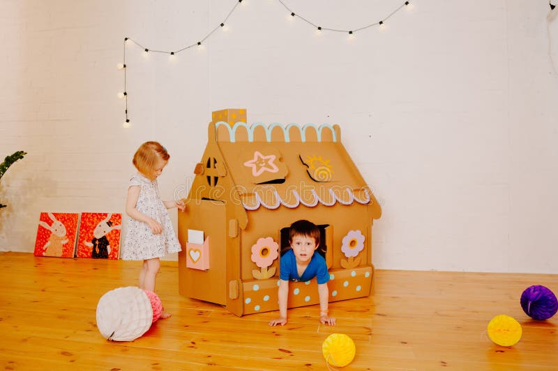 Joyful Siblings Running after Each Other and Around Cardboard House ...