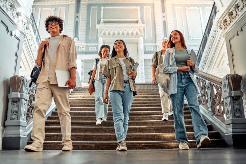 Joyful Students Go Down the Stairs in the University Building and Walk ...