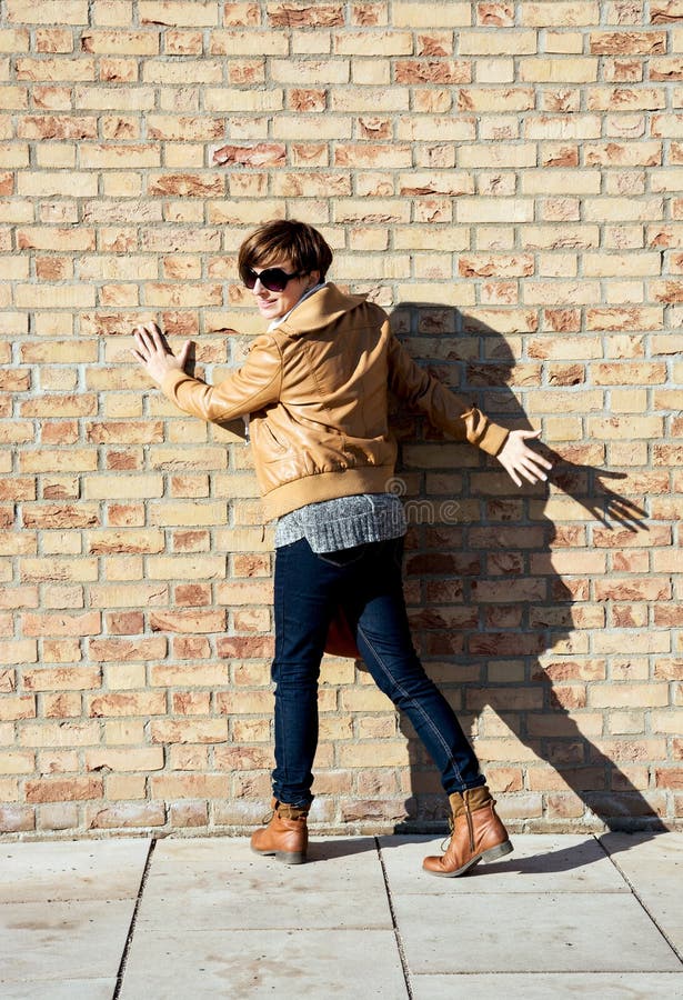 Joyful Woman Posing in Front of Brick Wall Stock Photo - Image of ...