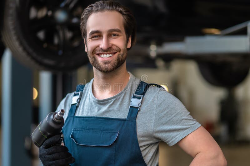 Joyful Young Car Mechanic Holding a Work Tool Stock Image - Image of ...