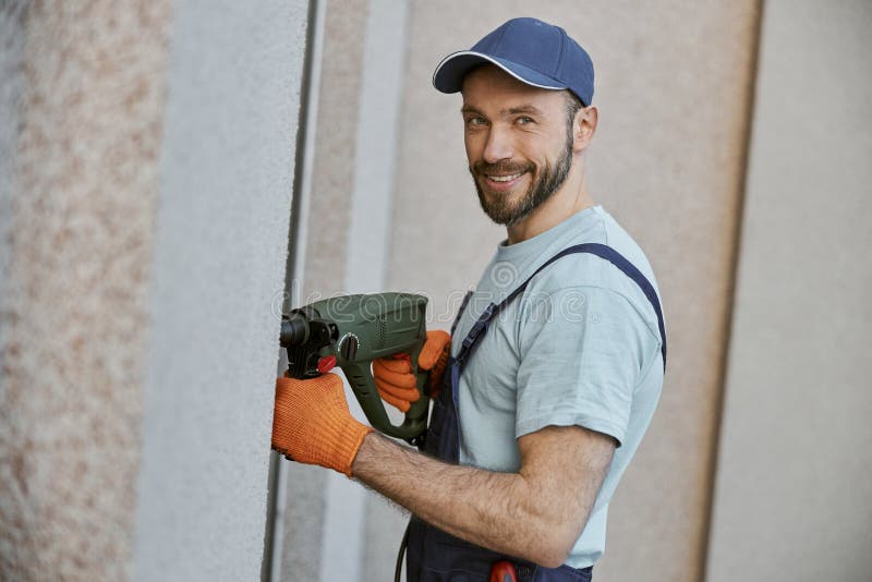 Cheerful Male Builder Drilling Wall with Electric Drill Stock Image ...
