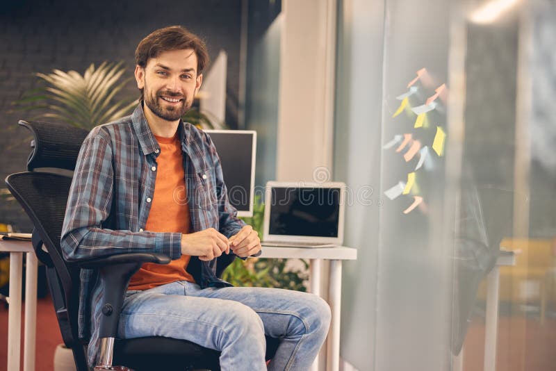 Joyful Young Man Sitting in Chair at Work Stock Photo - Image of ...