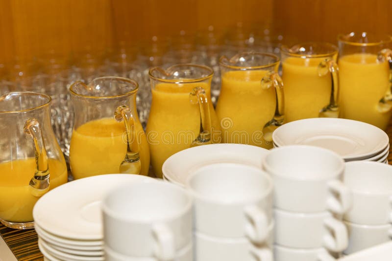 Jugs of Orange Juice, Rows of Empty Glasses and Stacks of Plates on a ...