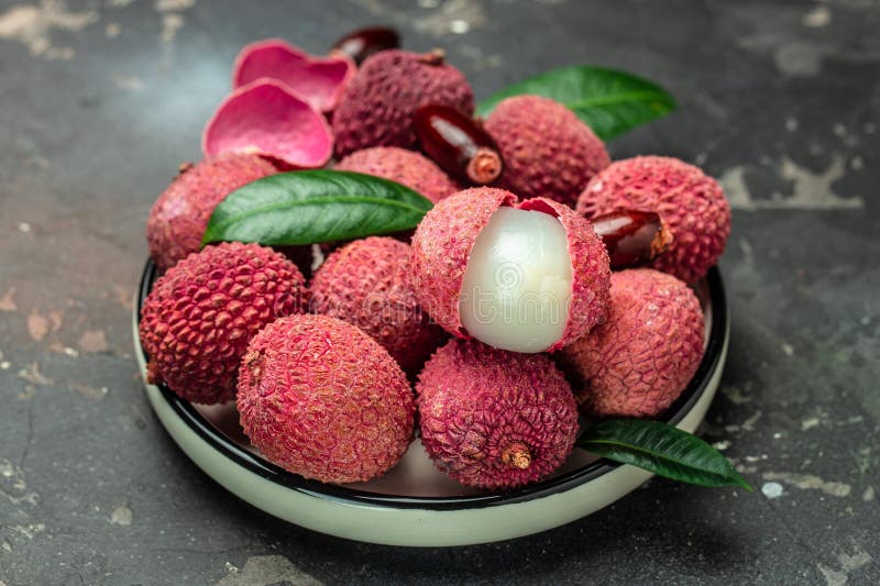 Juicy Lychee with Cut in Half and Leaves on Plate on a Dark Background ...