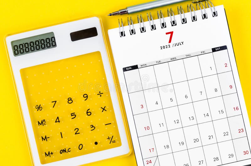 July 2022 Desk Calendar with Calculator and Pen on Yellow Background ...