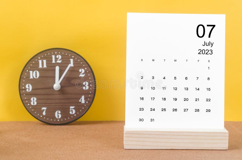 The July 2023 Monthly Calendar for 2023 Year with Clock on Yellow Table ...