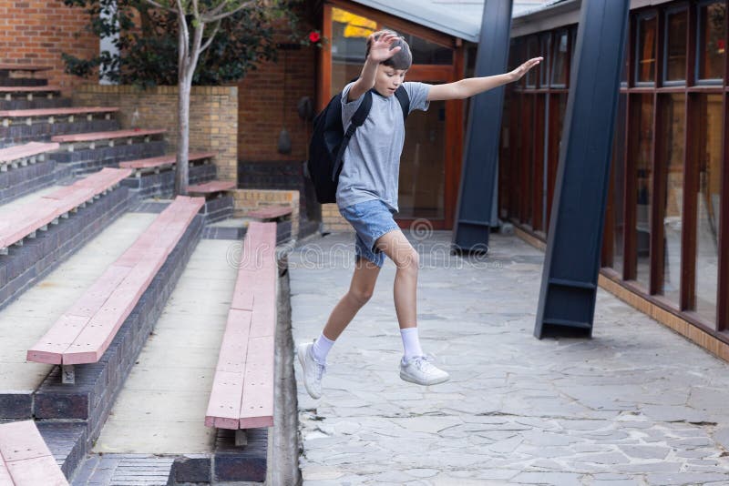 Jumping Down Steps, Boy with Backpack Enjoying Courtyard at School ...