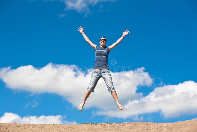Jumping Girl with Hands Up Against Stock Image - Image of happiness ...