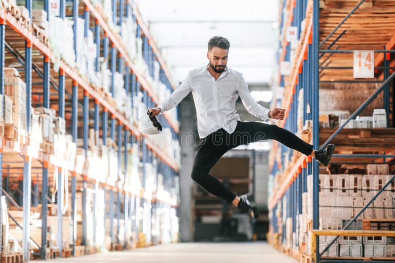 Jumping, Having Fun. Storage Worker is in the Warehouse with Bunch of ...