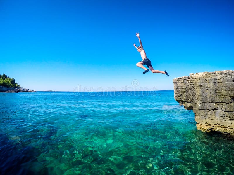 Jumping in to the sea stock photo. Image of child, plunge - 76517508