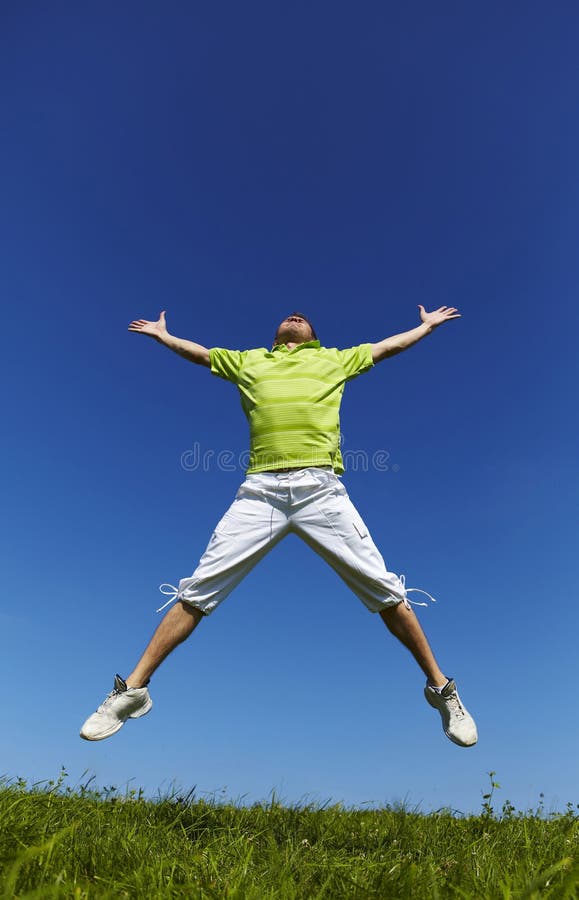 Jumping Up Guy in a Green Shirt Against Blue Sky. Stock Photo - Image ...