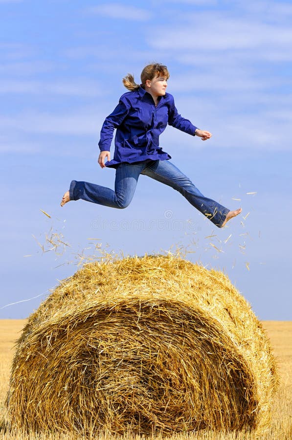 Jumping up on straw roll stock photo. Image of cloudy - 10571116