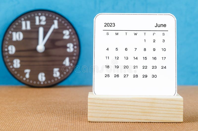 The June 2023 Monthly Calendar for 2023 Year with Clock on Wooden Table ...