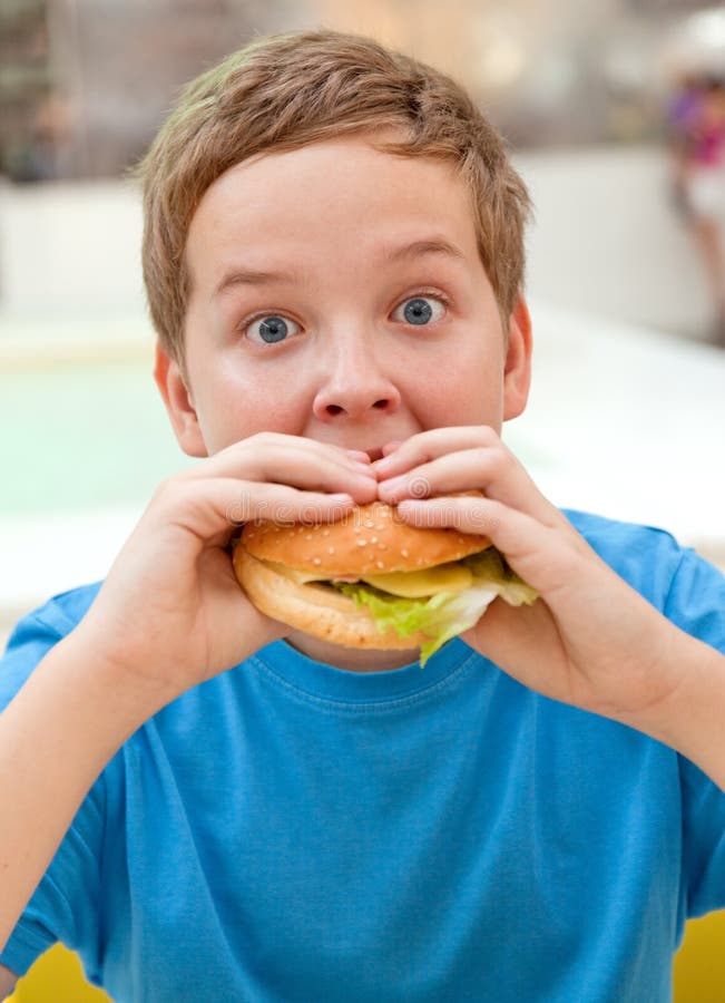Junge, der Hamburger isst stockbild. Bild von tiefstand - 26173993