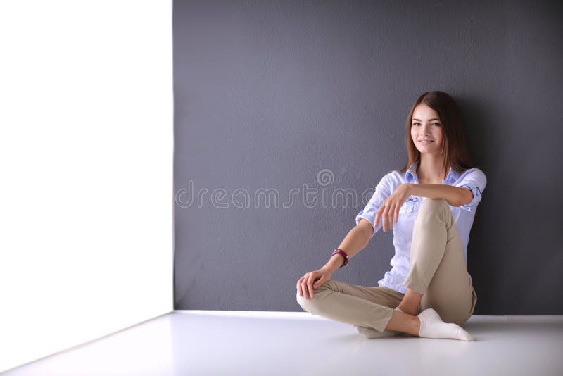 Junge Frau Die Auf Dem Boden Nahe Dunkler Wand Sitzt Stockfoto Bild