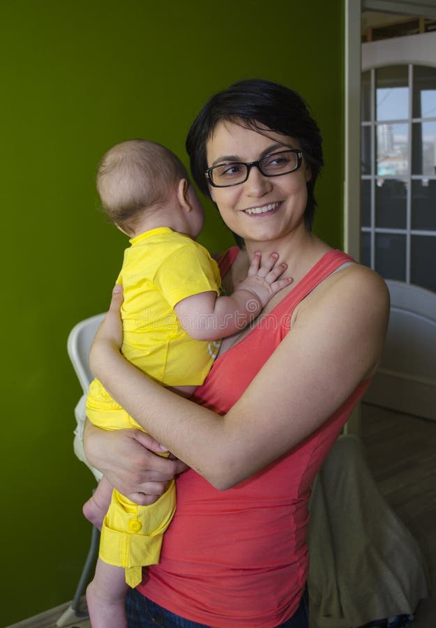 Mutter Mit Ihrem Baby In Ihren Armen Nahe Bei Der Garderobe Stockbild ...