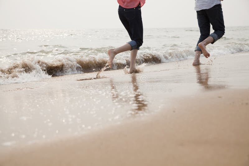Junge Paare, Die in Die Wellen Laufen Stockfoto - Bild von fokus ...