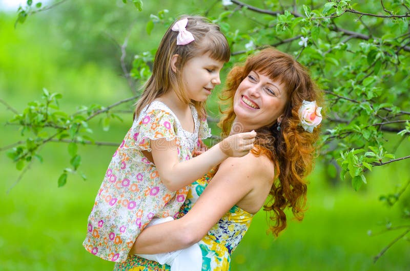 Junge Schöne Mutter, Die Mit Ihrer Tochter Im Garten Geht Stockfoto ...