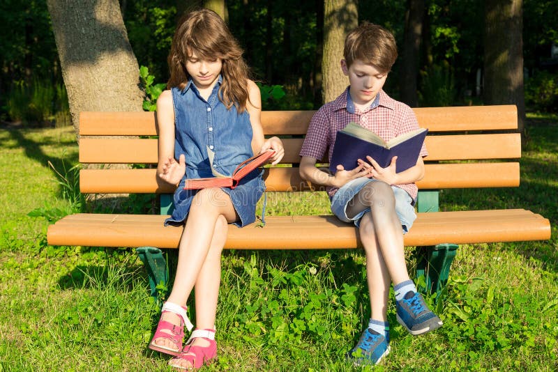Junge Und Mädchen Sitzen Auf Einer Bank Im Park Und Betrachten ... Junge Und Mädchen Sitzen Auf Einer Bank Im Park Und Betrachten ...