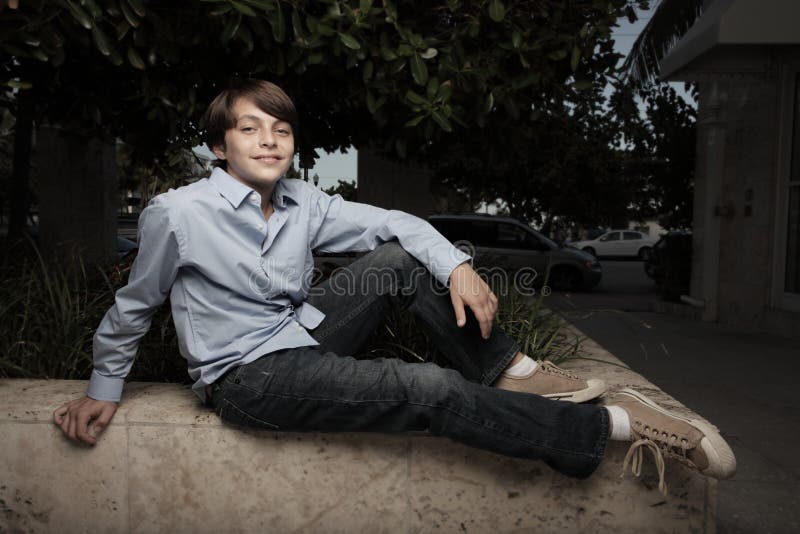 Junger Stilvoller Junge, Der Auf Einer Leiste Sitzt Stockfoto - Bild ...