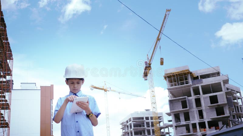 Junior Construction Supervisor: Boy in a Hard Hat at Building Site with ...