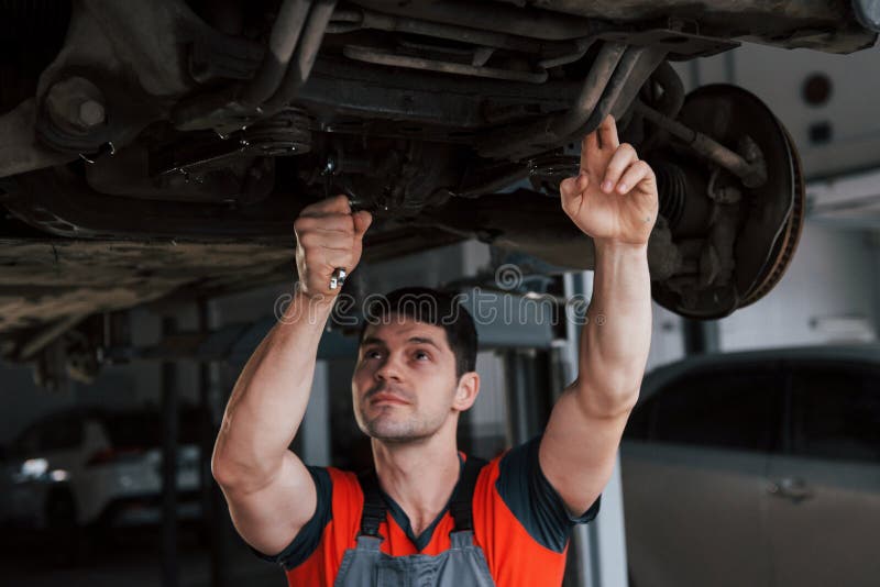 Just a Few Final Moves. Man at the Workshop in Uniform Fixes Broken ...