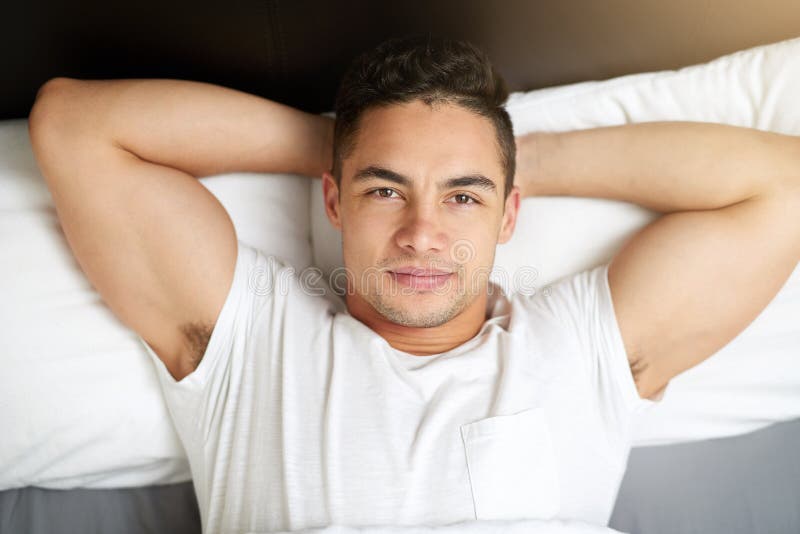 Just Lay Back And Relax A Handsome Young Man Lying In Bed Stock Image