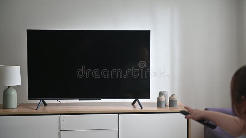 4K Back View of Person Using Remote Control Switching Television ...