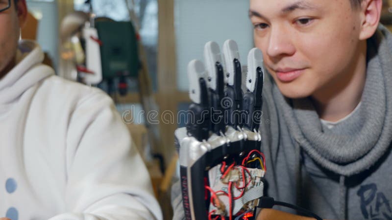 Engineer with Prosthetic Hands Works at a Factory, Drilling a Wooden ...