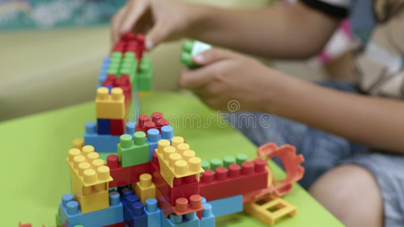4K. a Close-up of a Child Assembling a Developing Lego Set, Sitting at ...