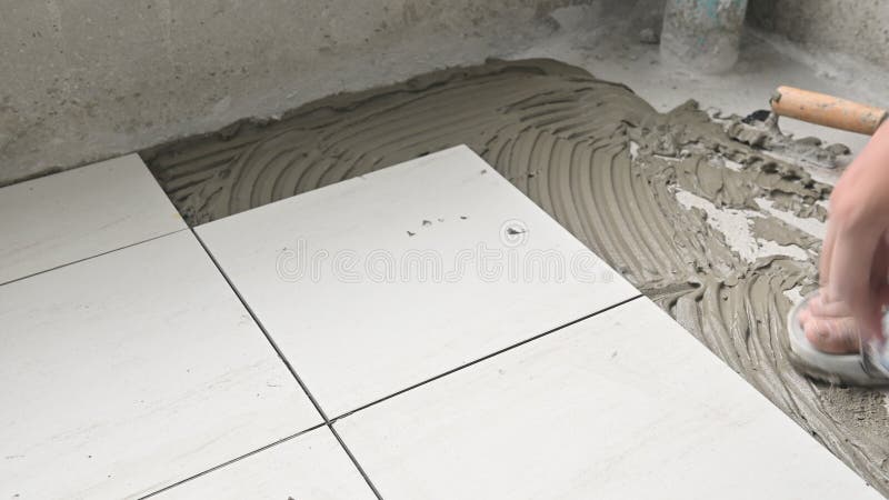 4K Construction Workers Laying Tile Over Concrete Floor Using Tile ...