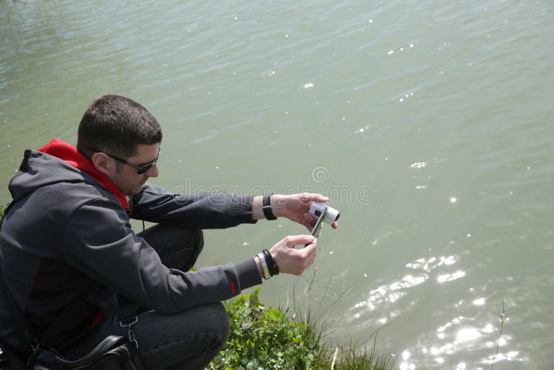 4K Digital Camera in the Hands of a Young Man Shooting on the River ...