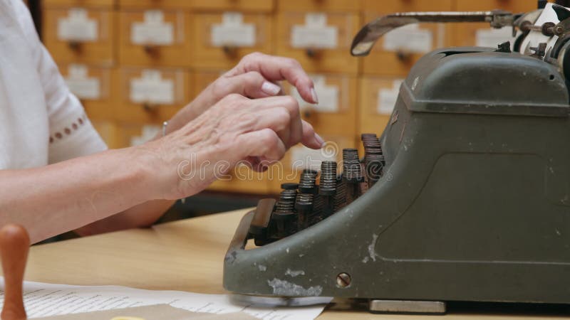 4K. an Elderly Woman Typing on a Typewriter in the Library Stock Video ...