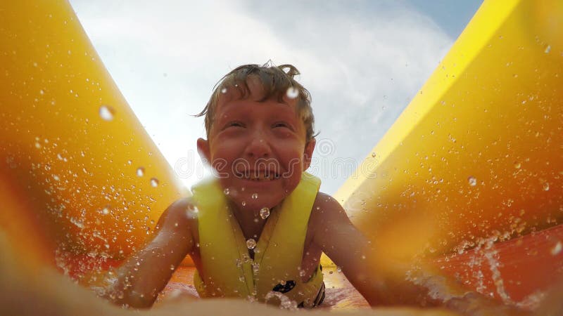 4K Video: Little Boy Slides Fast by the Inflatable Slide into the Water ...