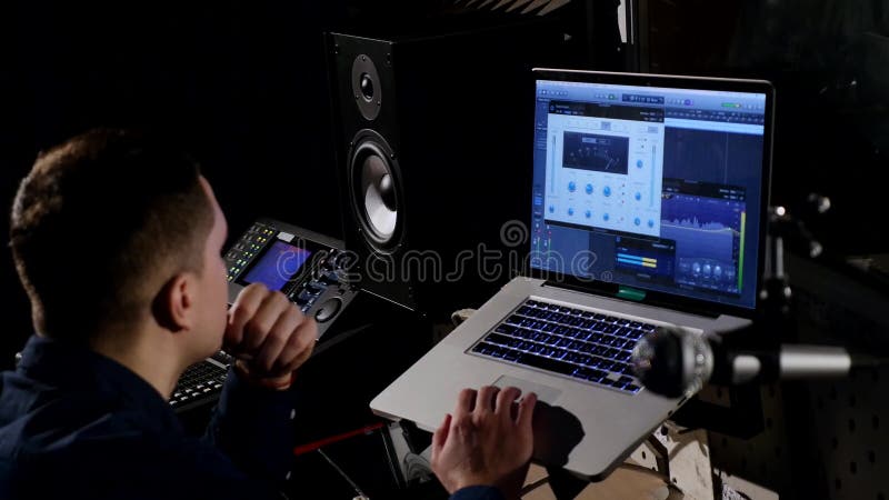 4K Young Sound Engineer in Recording Studio Using Laptop at the Mixing ...