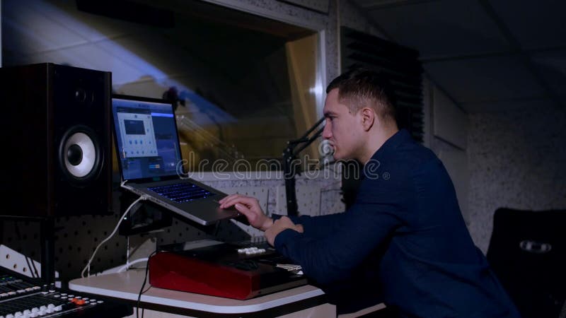 4K Young Sound Engineer in Recording Studio Using Laptop at the Mixing ...