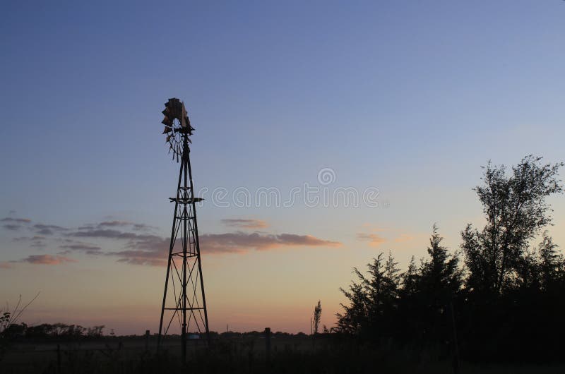 Kansas Windmill at Sunset with a Colorful Sky with the Sun Stock Photo ...