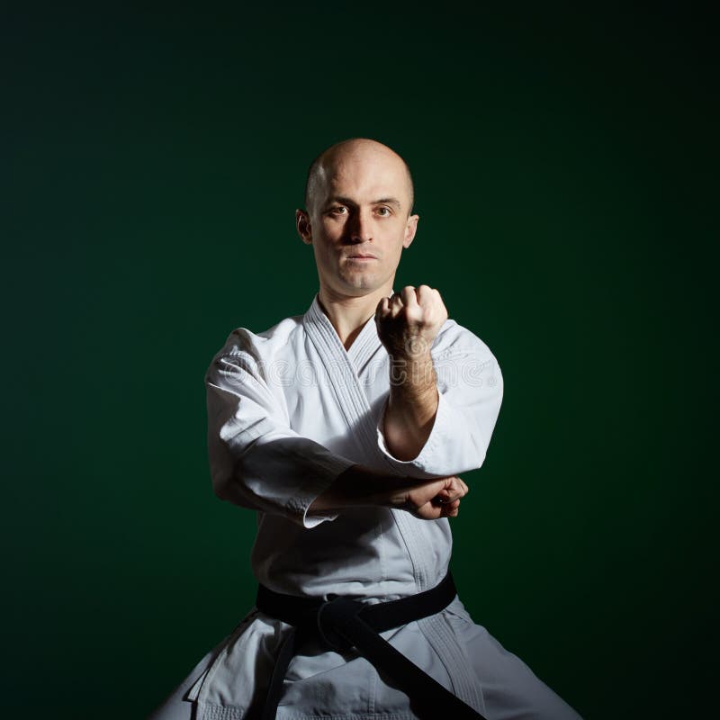 On a Dark Green Background, an Athlete in Karategi Trains Formal Karate ...