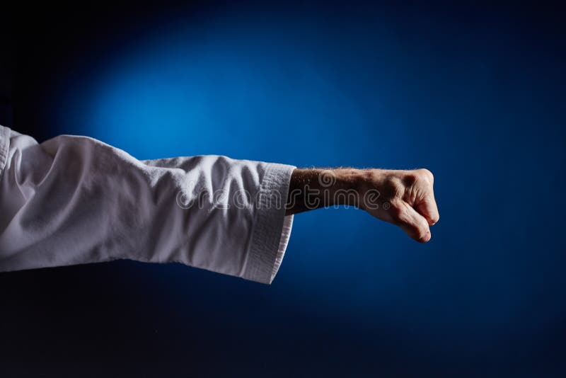 At Karategi Athlete Performs a Punch Arm on a Blue Background Stock ...