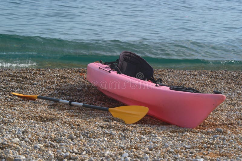 Kayak on a pebble beach stock photo. Image of pink, outdoor - 25836528