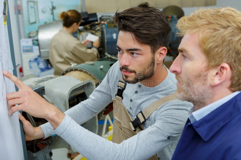 Keen Engineer Studying Diagram on Notice Board with Supervisor Stock ...