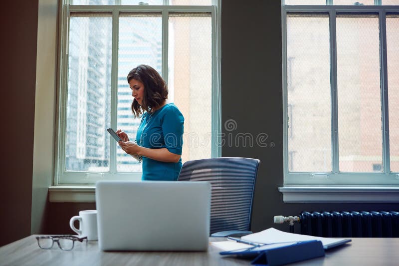 Keep Connected, Keep in the Know. a Businesswoman Using a Phone in an ...