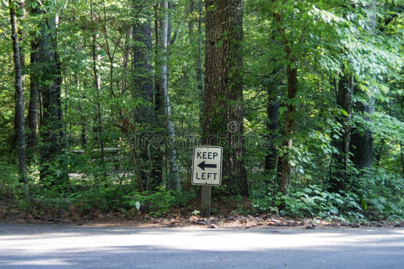 Keep Left Sign in the Forest Along the Roadway Stock Photo - Image of ...
