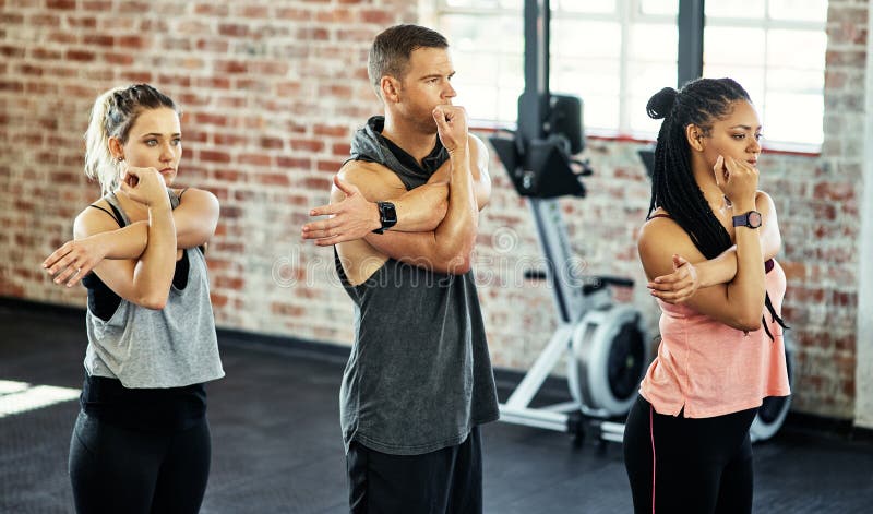 Keep those Muscles Loose. a Focused Group of Young People Standing in a ...